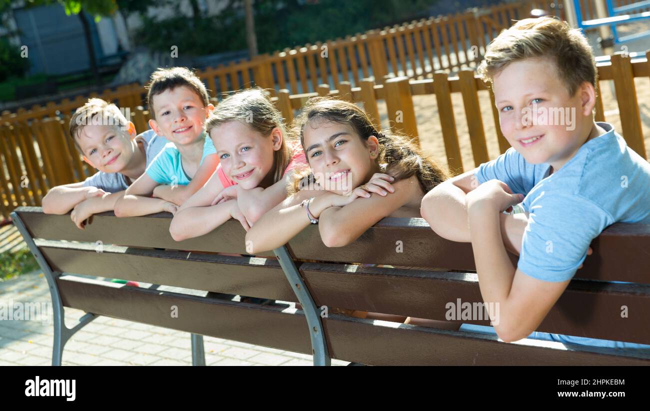 Glad children sitting on a bench Stock Photo - Alamy