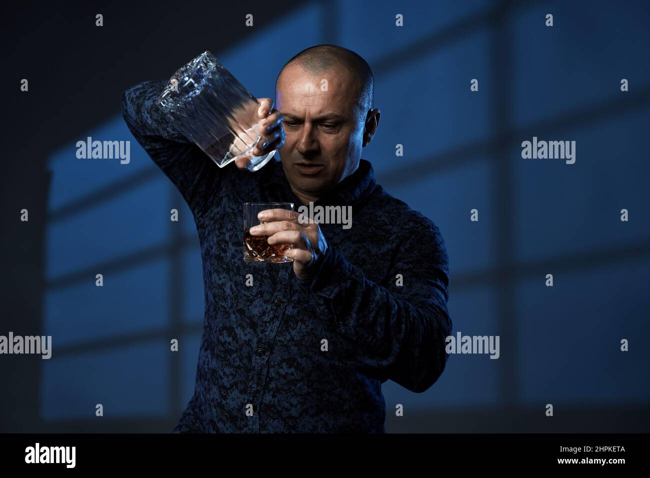 Businessman checking his empty whiskey bottle after pouring the last ...
