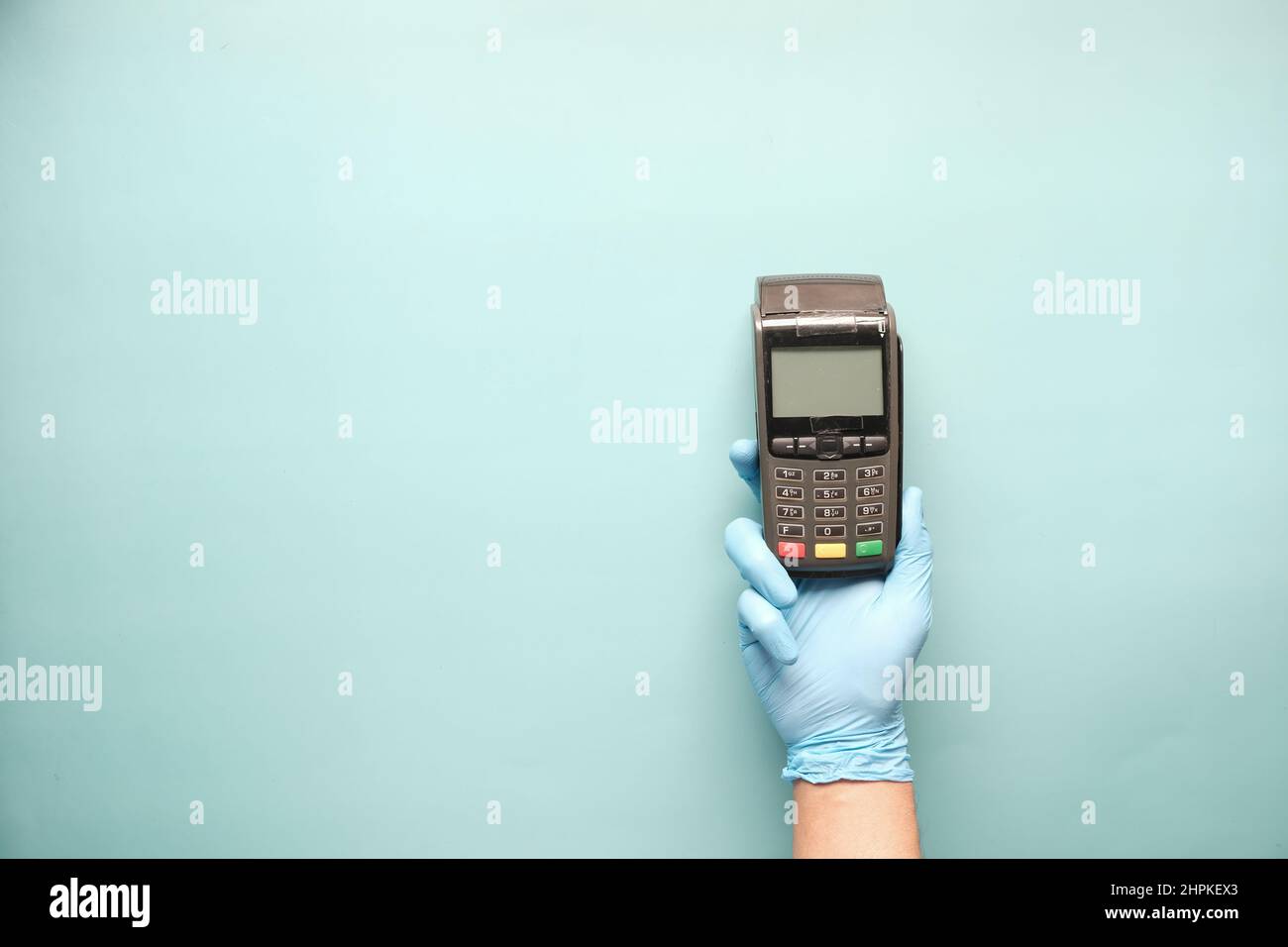 hand in a latex gloves holding pos machine Stock Photo - Alamy