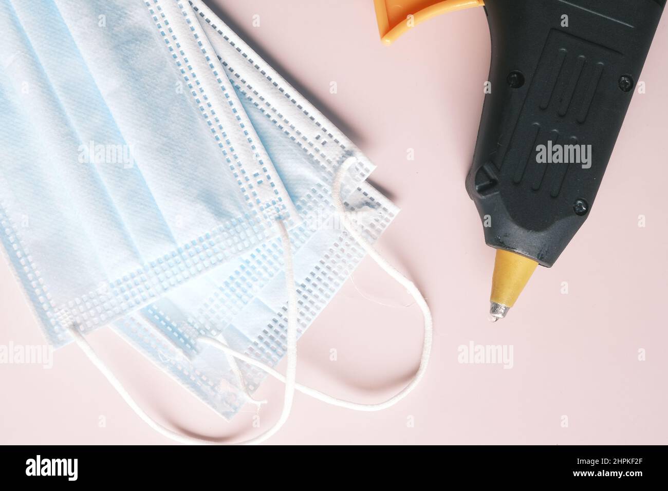 applying glue on blue surgical masks to fix it Stock Photo - Alamy