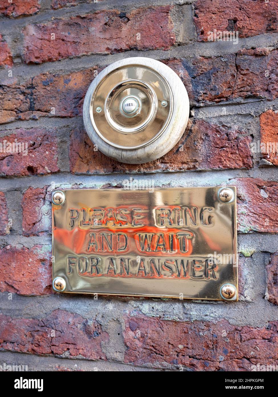 Shiny brass bell with plaque. 'please ring the bell and wait for an ...