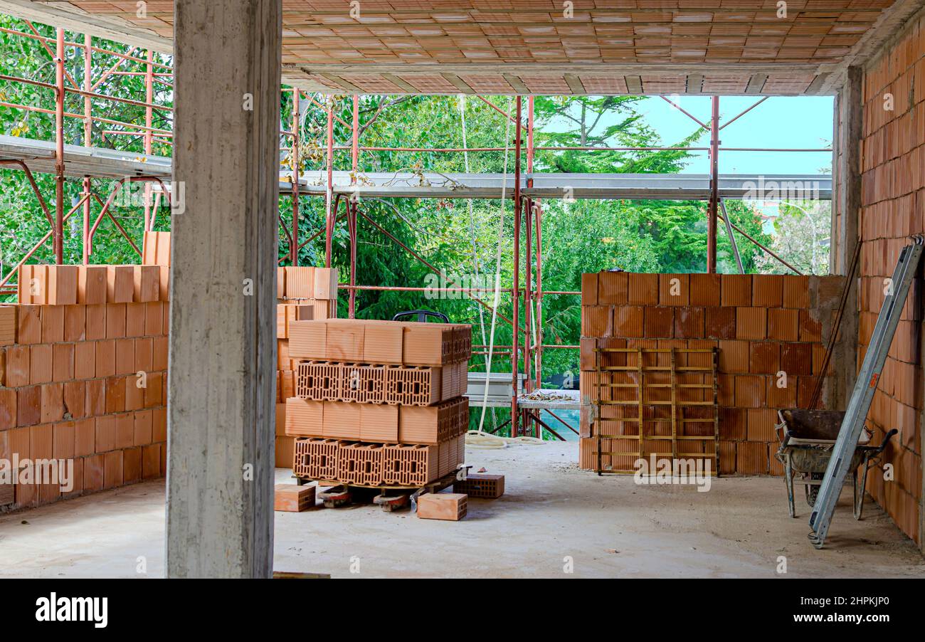 Stack of brick bricks, shovel, broom and other work tools of a ...