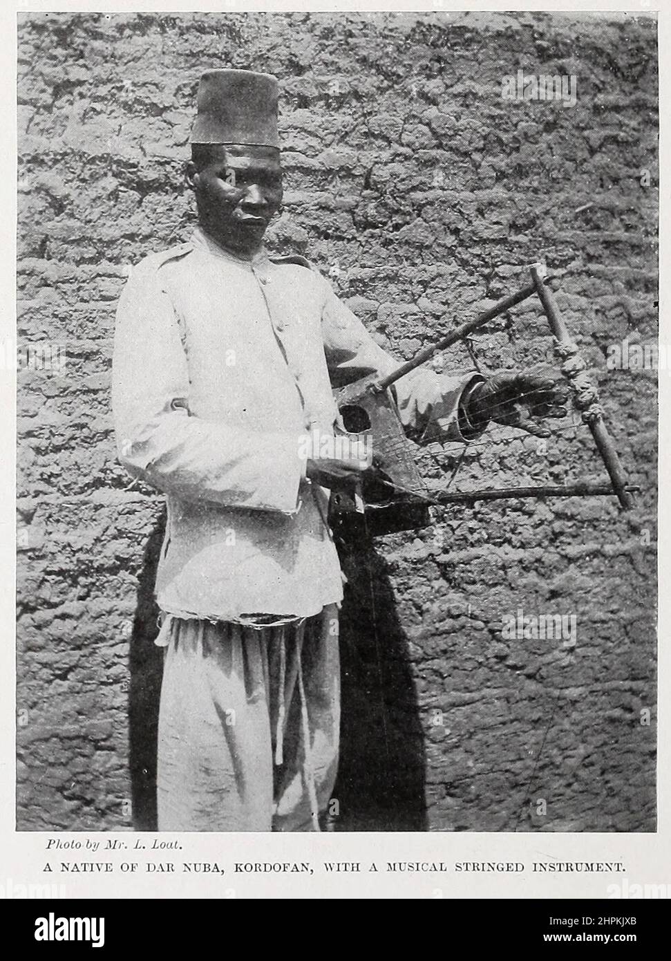 A NATIVE OF DAR NUBA, KORDOFAN, SUDAN WITH A MUSICAL STRINGED ...