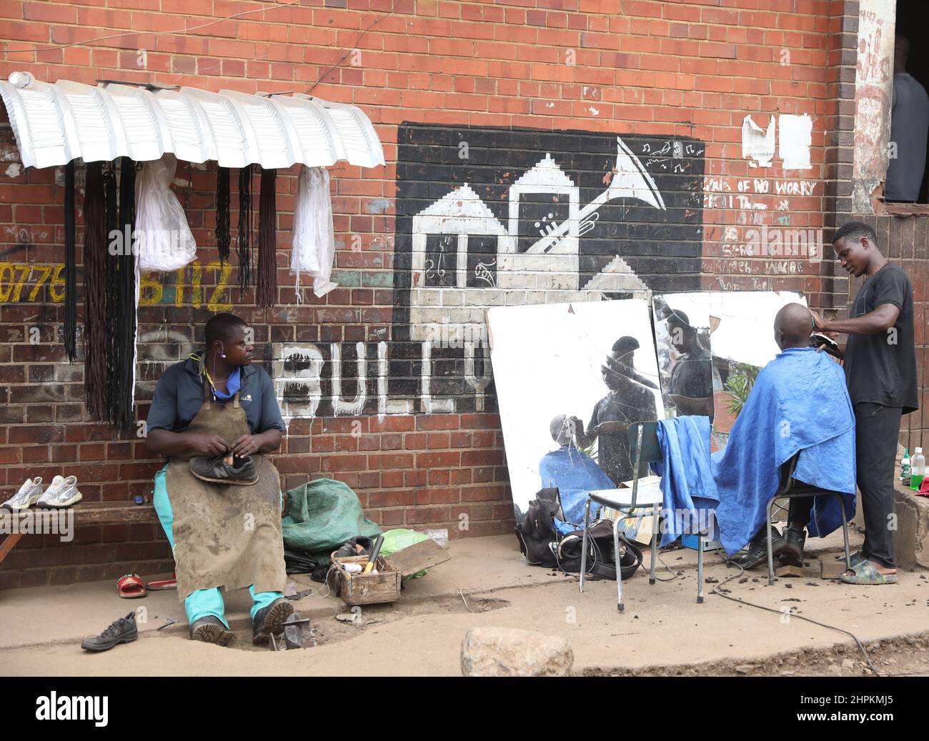 (220222) -- HARARE, Feb. 22, 2022 (Xinhua) -- A barber and a shoe ...