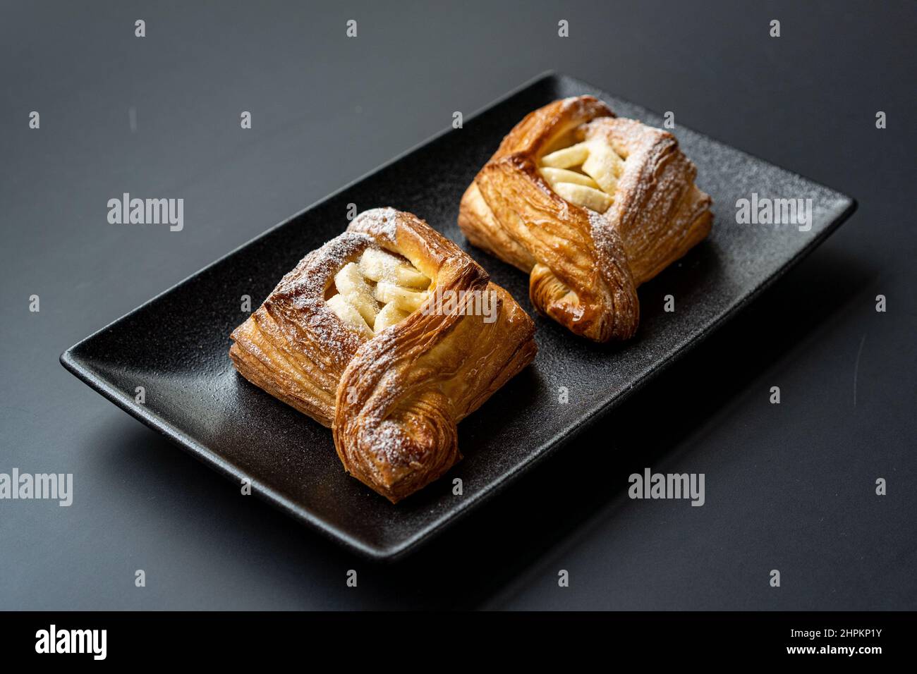 dessert is a small puff pastry pie with stuffing inside on a black ...