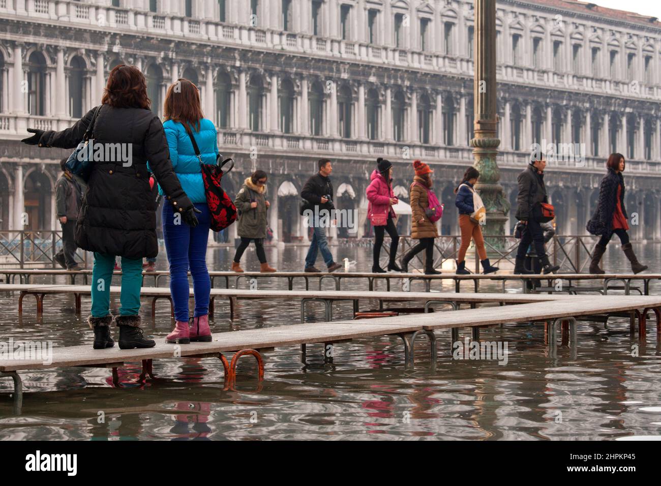 Tourists walking on elevated walkways in San Marco square flooted by ...