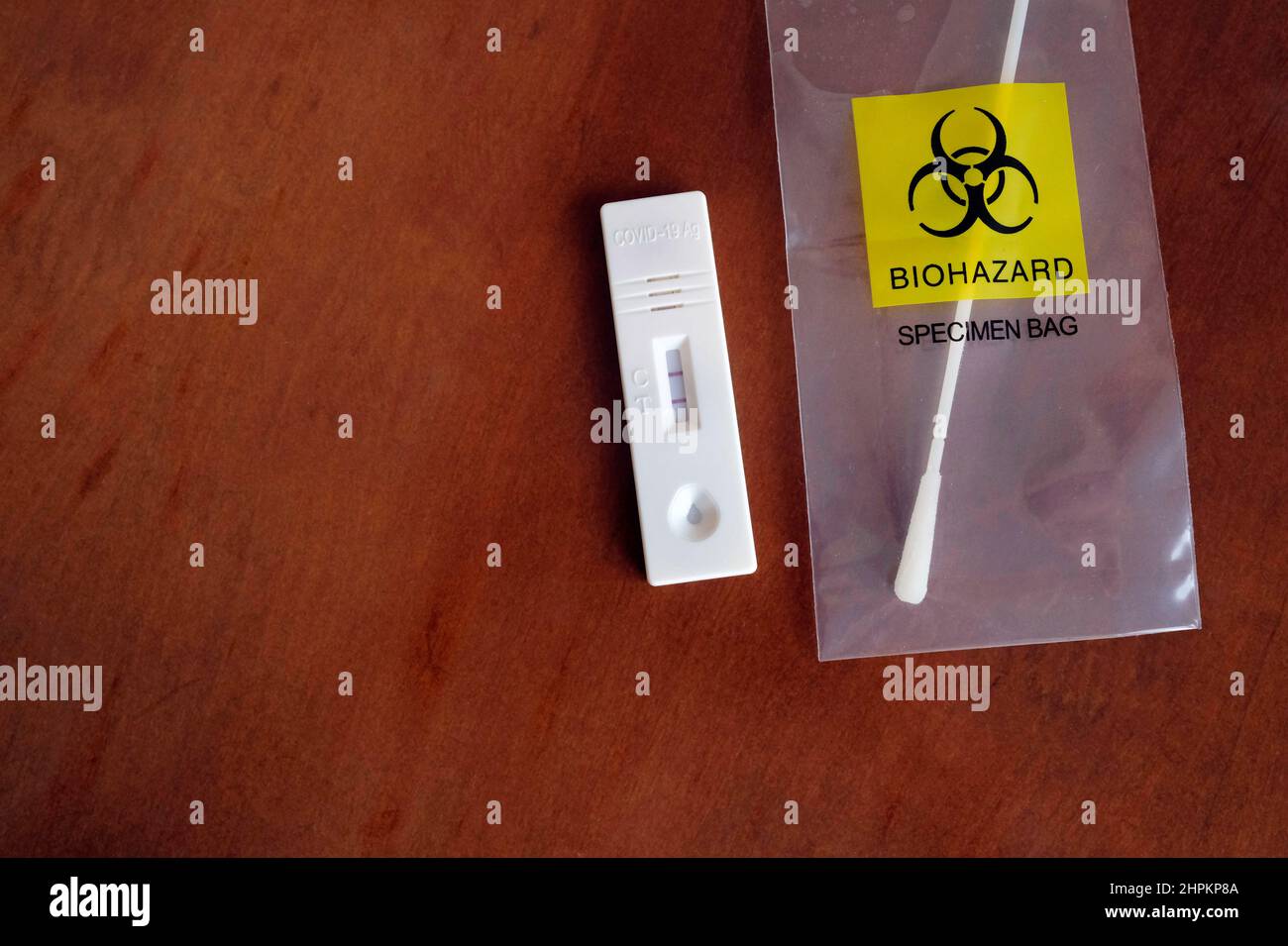 Coronavirus (COVID-19) rapid test with positive result next to a nasal ...