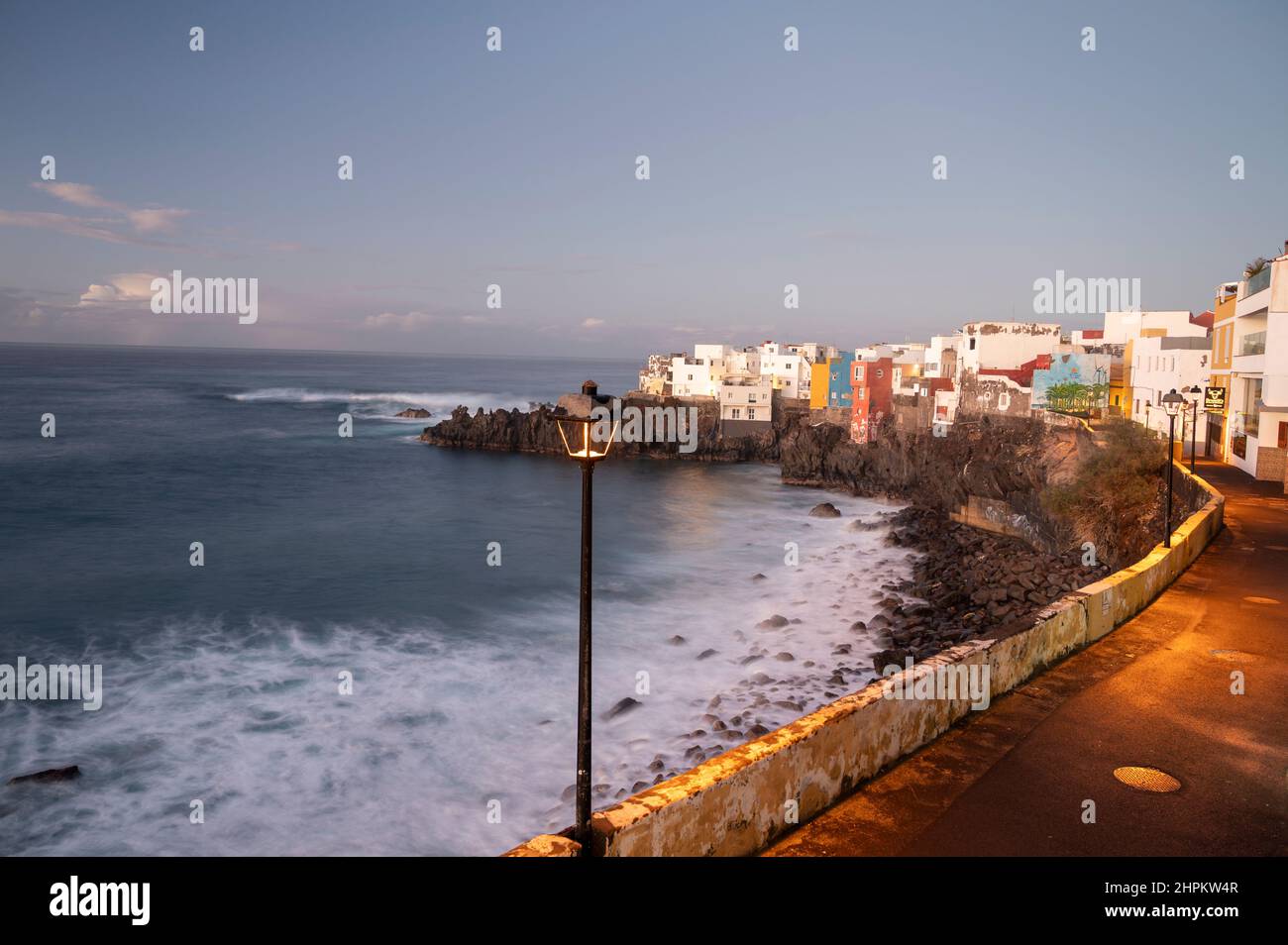 View on colorful houses and black lava rocks in small fisherman village ...