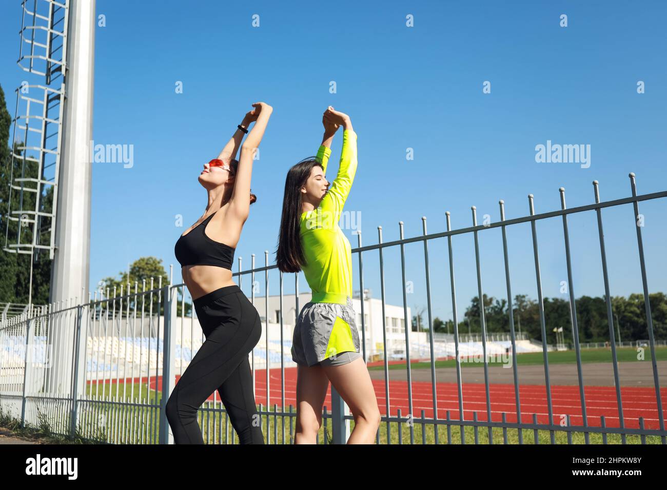 Sporty young sisters at stadium on sunny day Stock Photo - Alamy