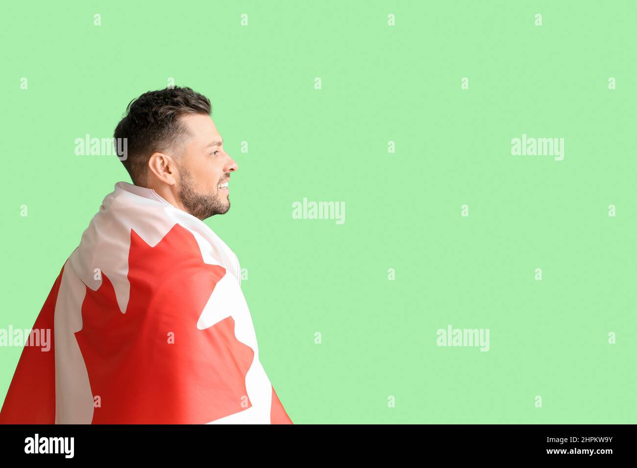 Handsome man with flag of Canada on green background Stock Photo - Alamy