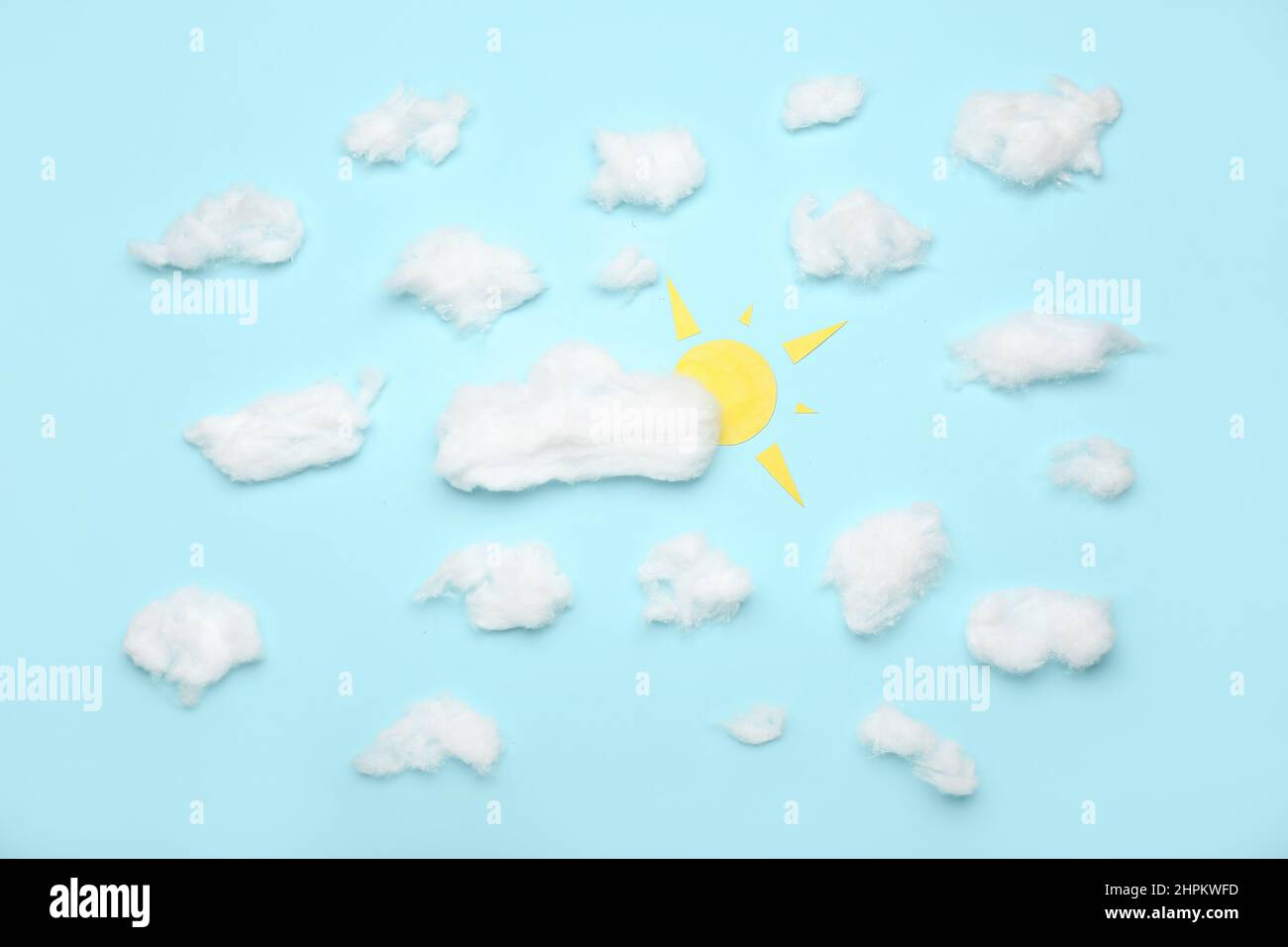Creative composition with cotton wool clouds and paper sun on color ...