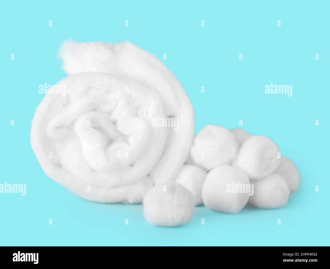 Roll of cotton wool and balls on color background Stock Photo - Alamy