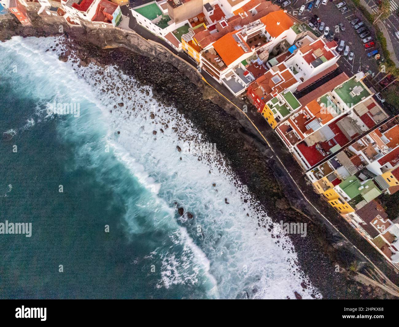 Aerial top view on colorful houses and black lava rocks in small ...