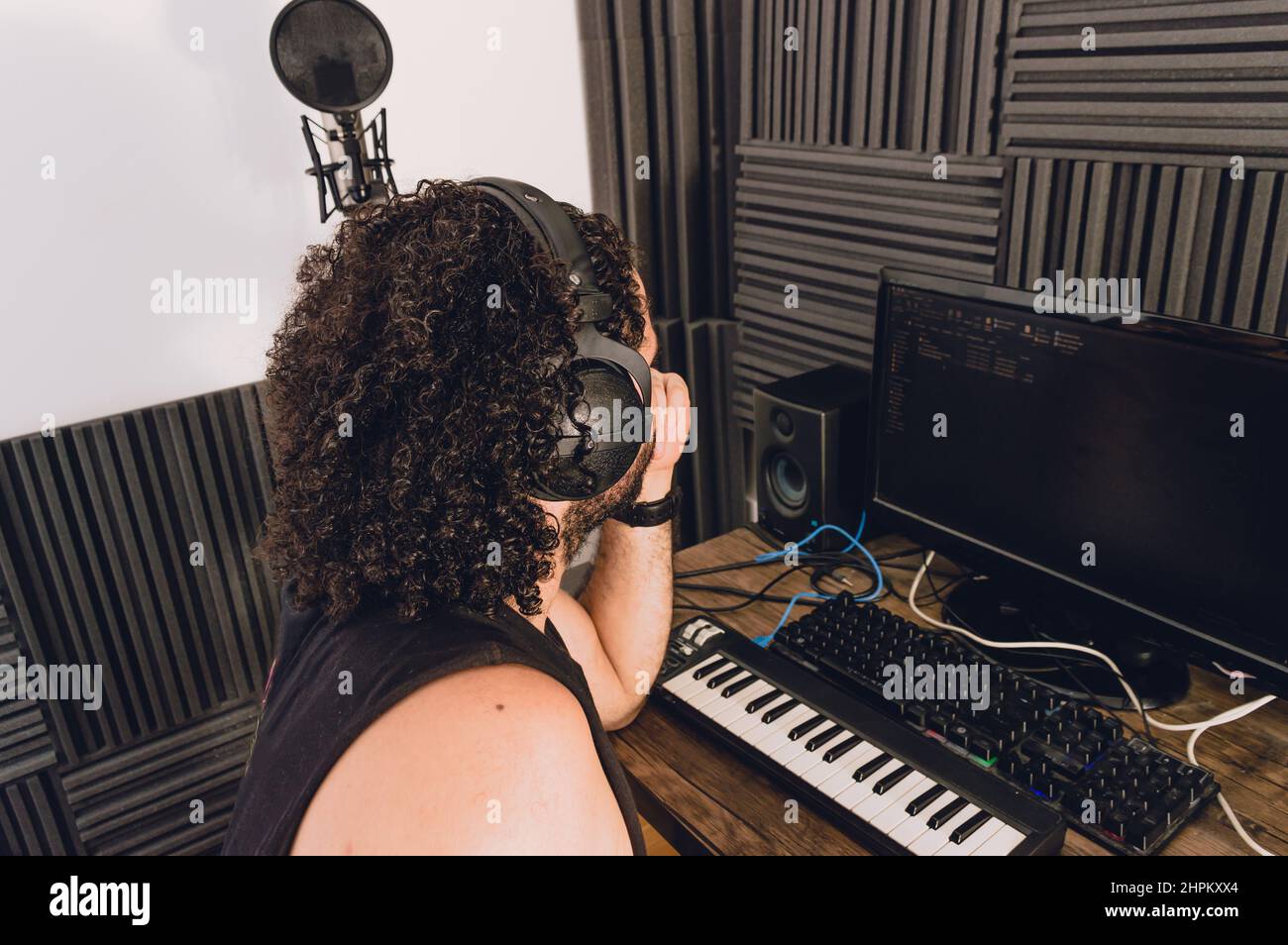 side view of unrecognizable caucasian man in his home recording studio ...