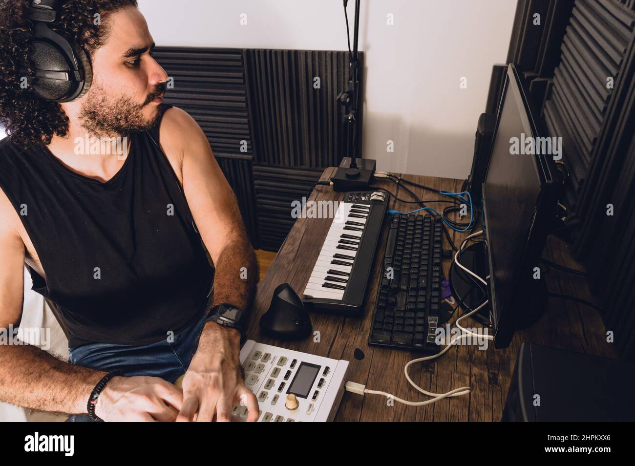bearded young caucasian man watching the computer, mixing music and ...