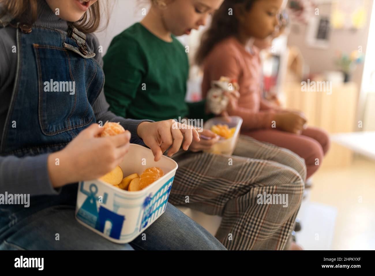 Group of classmates having fruit snack during break at school Stock ...