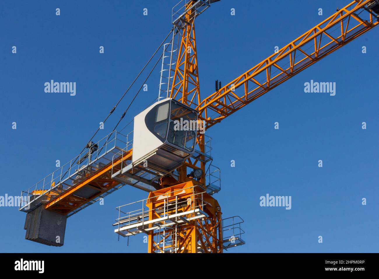 Tower crane against the blue sky. Tower crane operator's cabin. Crane ...