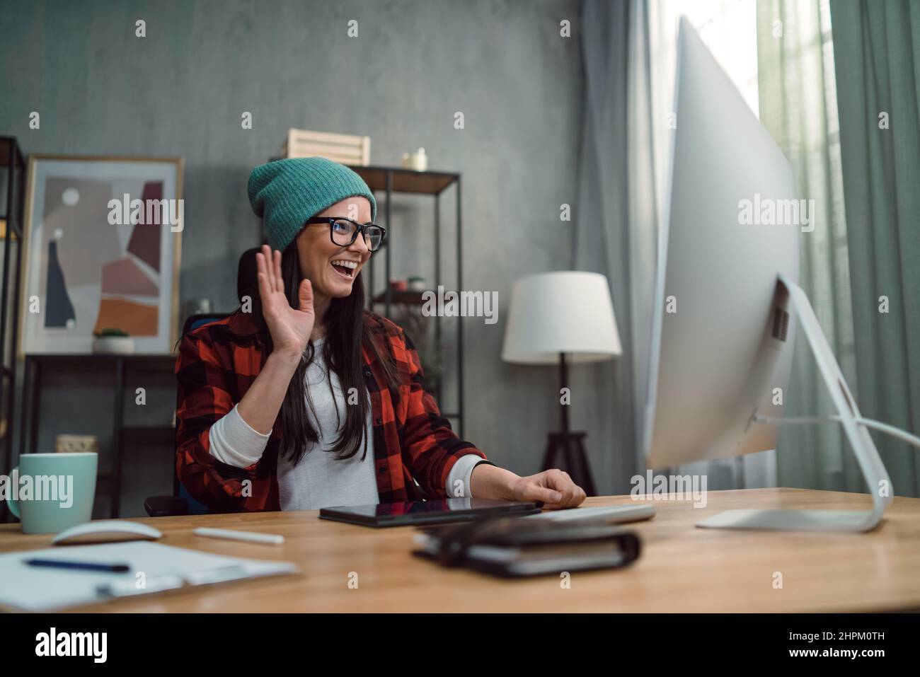 Female video editor having a vide call with her colleagues indoors in ...