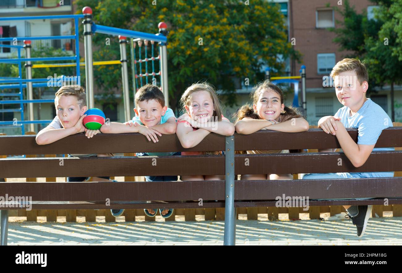 Five glad children sitting on a bench Stock Photo - Alamy
