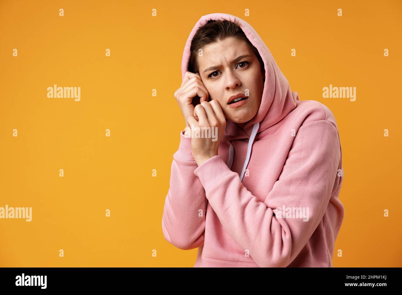 Portrait of the young scared teen woman against yellow background Stock ...