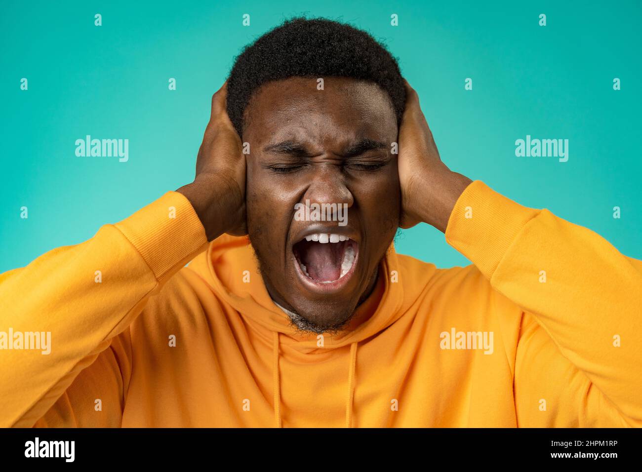 Emotional screaming young african man standing isolated over mint ...