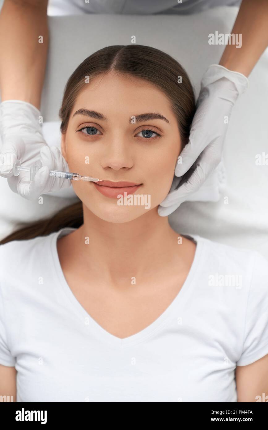 Top view portrait of cute young woman in white shirt on procedure ...