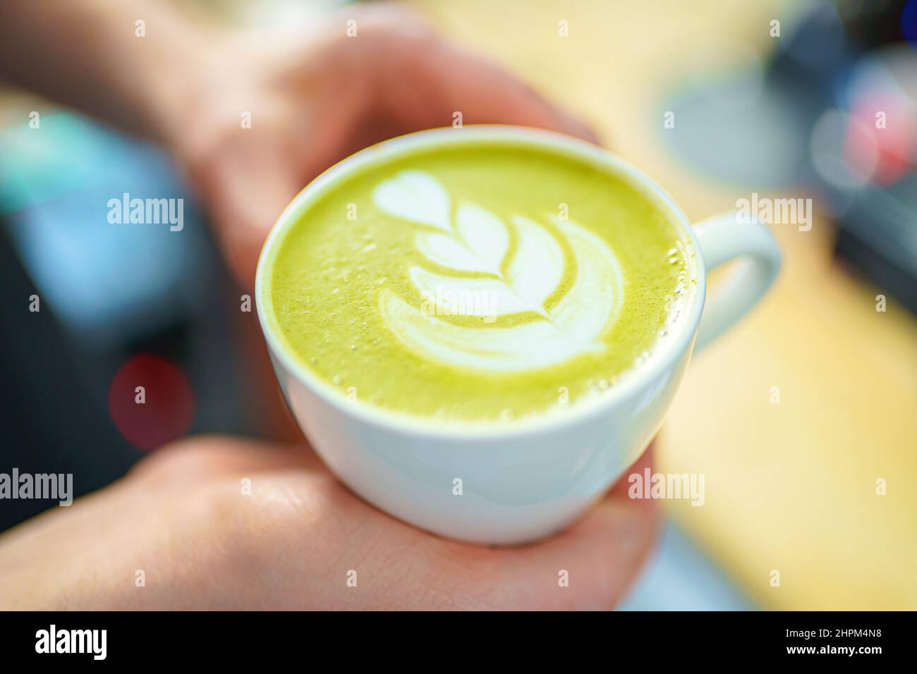 barista holding a cup of matcha latte in her hands Stock Photo - Alamy