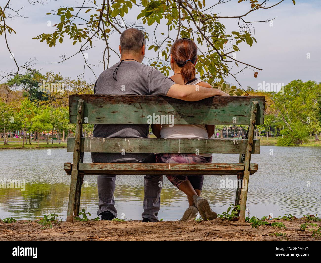 Couple Sitting on a Park Bench Stock Photo - Alamy
