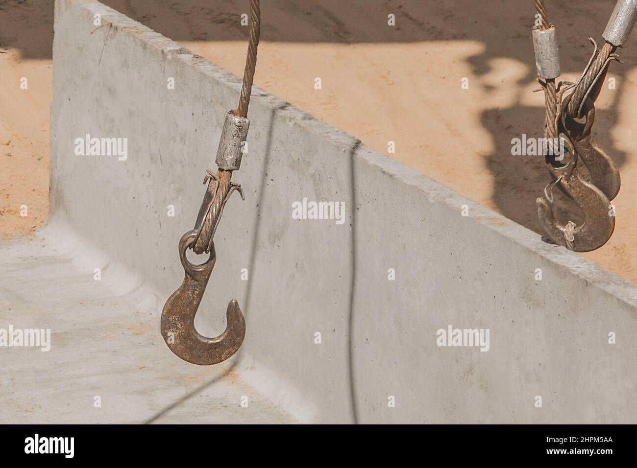 Heavy iron hook lifting mechanism with a steel cable rope with a ...