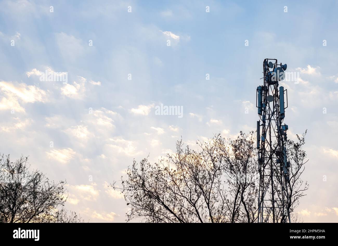 Mobile network tower under the bright sky before the evening with copy ...