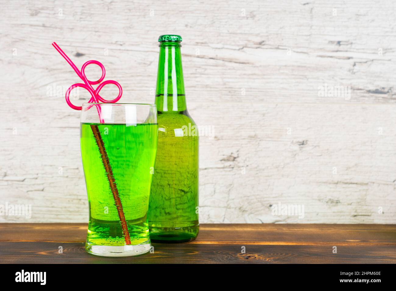 green soft drink with cocktail pipe and bottle on table Stock Photo - Alamy