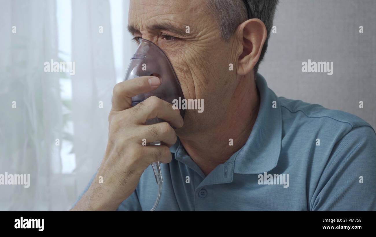 An elderly man is using an inhaler. Treatment of airway inflammation ...