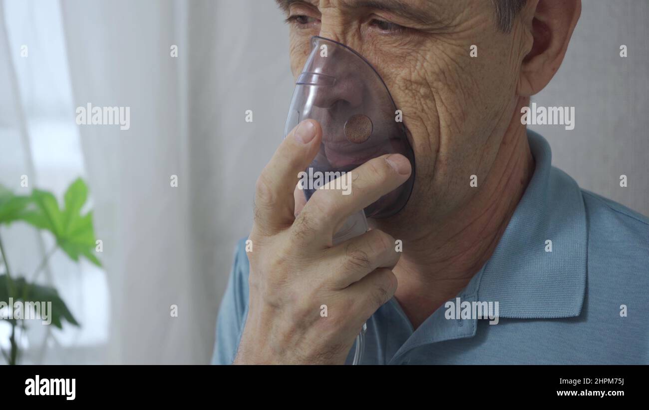 An elderly man is using an inhaler. Treatment of airway inflammation ...