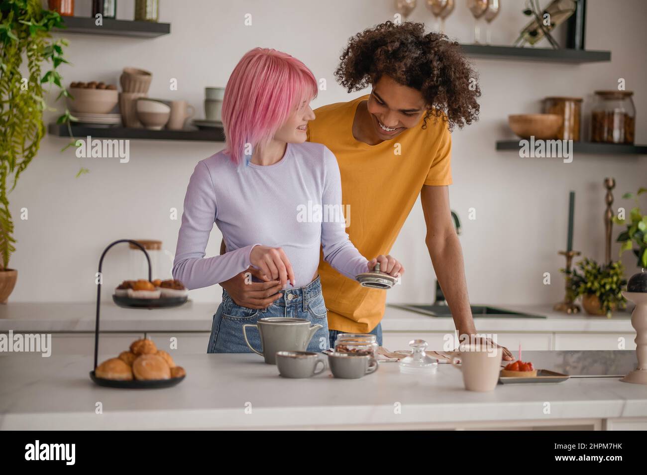 A couple making tea in the kitchen Stock Photo - Alamy