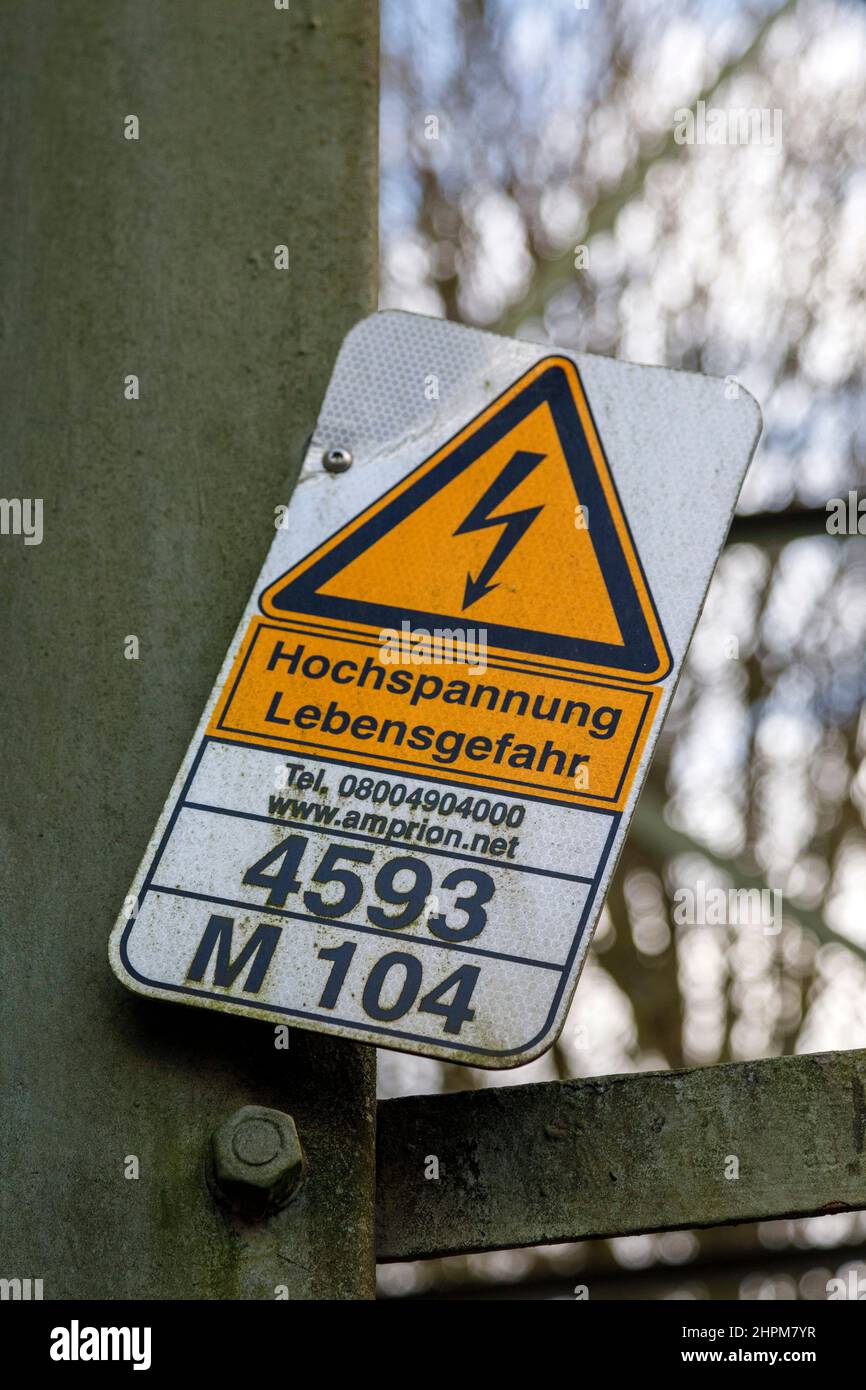 High voltage danger to life, warning sign on an overhead power line ...