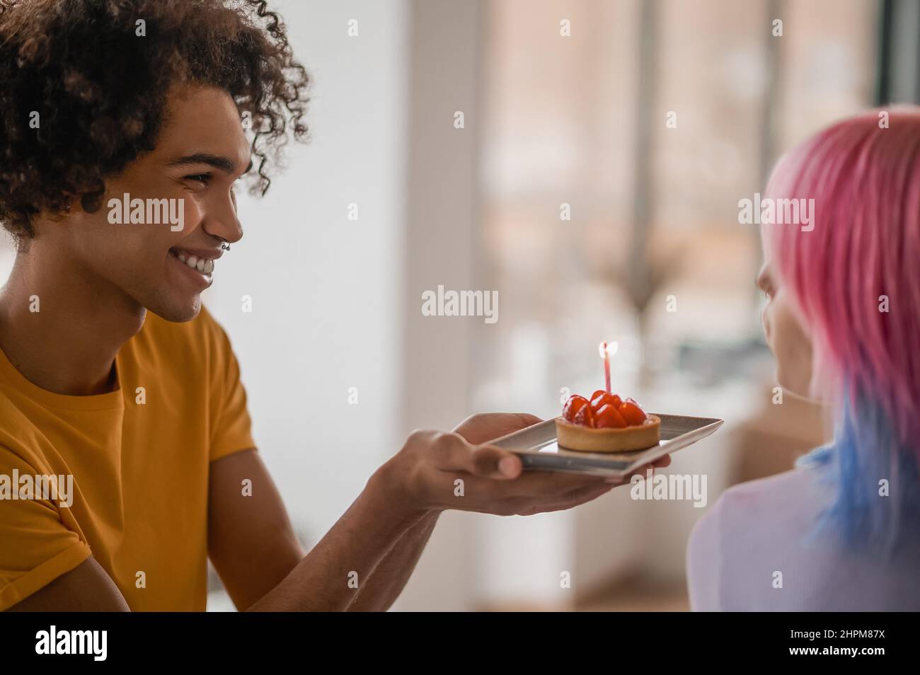Smiling young man giving a present to his girlfriend Stock Photo - Alamy