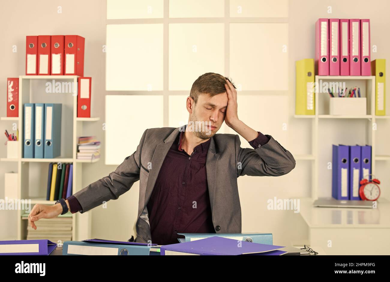 so exhausted. man wear office suit. male realtor has hard working day ...