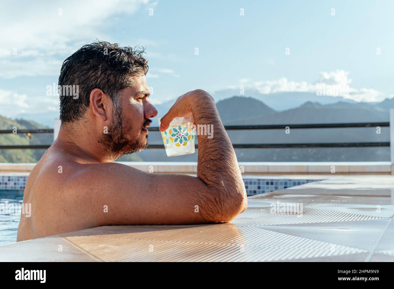 Man drinking in a pool enjoying the view of the city of Chanchamayo ...