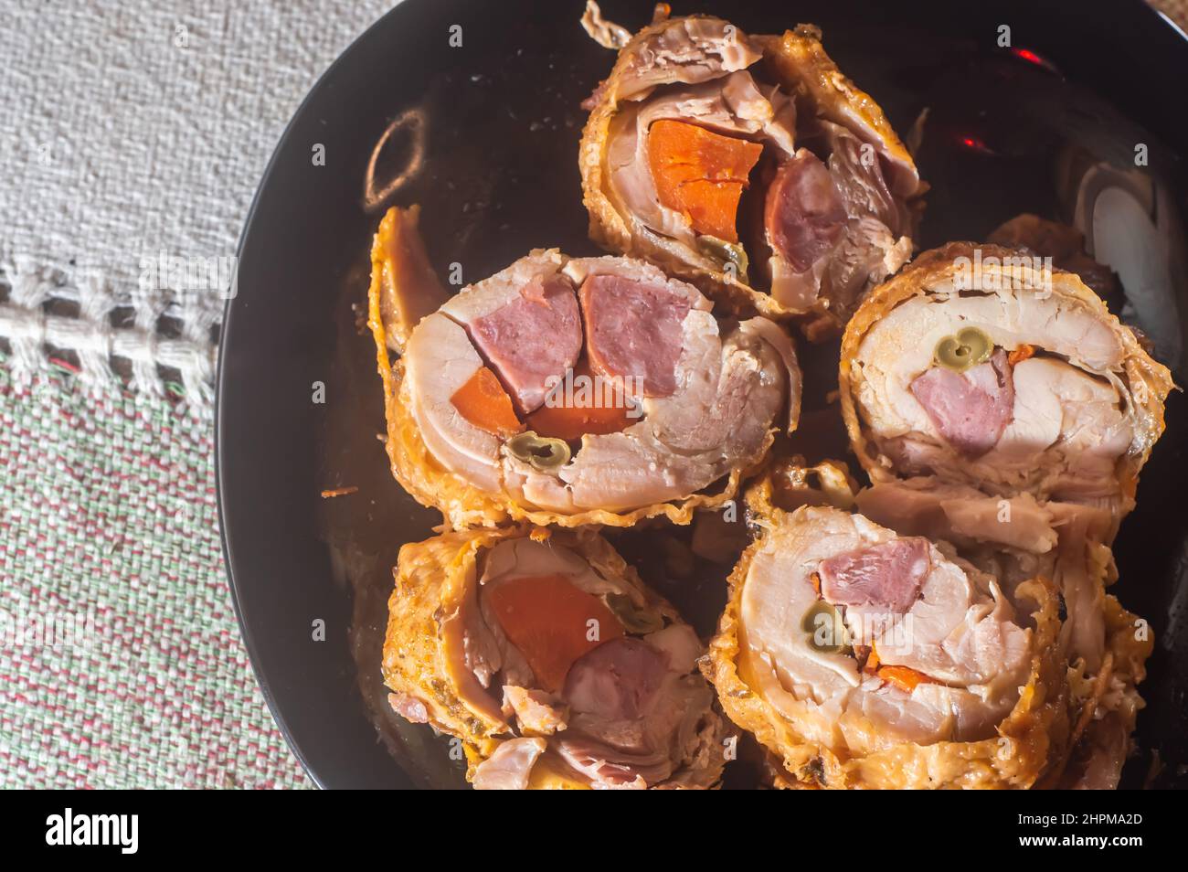 stuffed chicken rolls roast placed on a black plate,copy space left ...