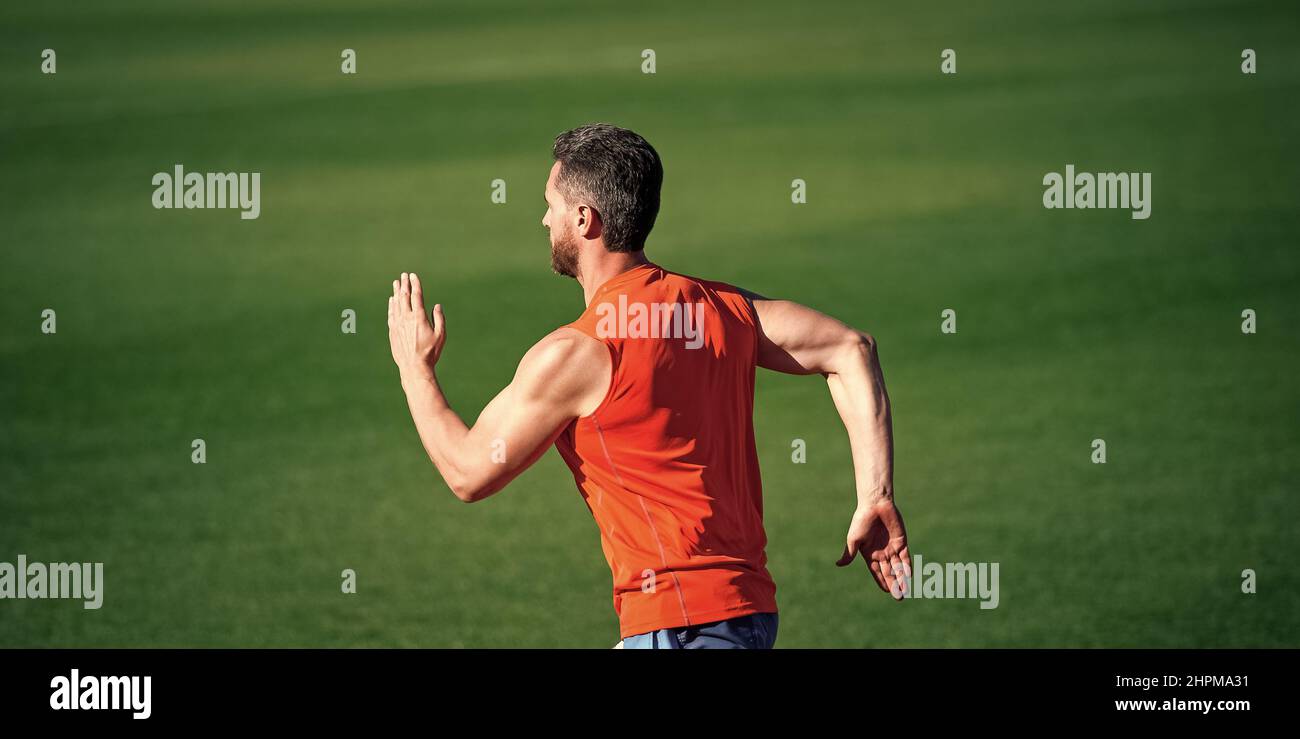 athletic muscular guy running on racetrack at outdoor stadium, motion ...