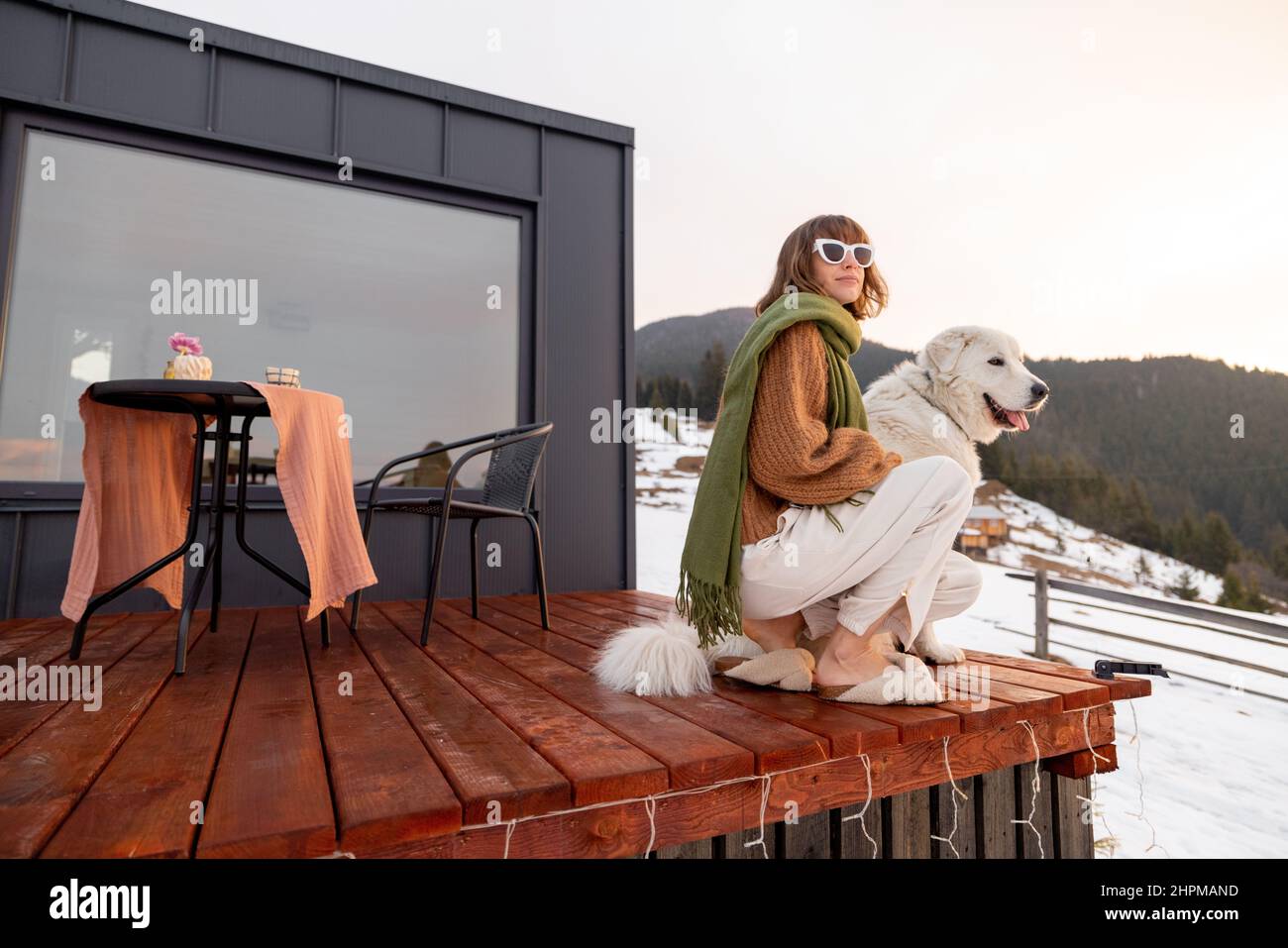 Woman with her dog resting on terrace of tiny house on nature Stock ...