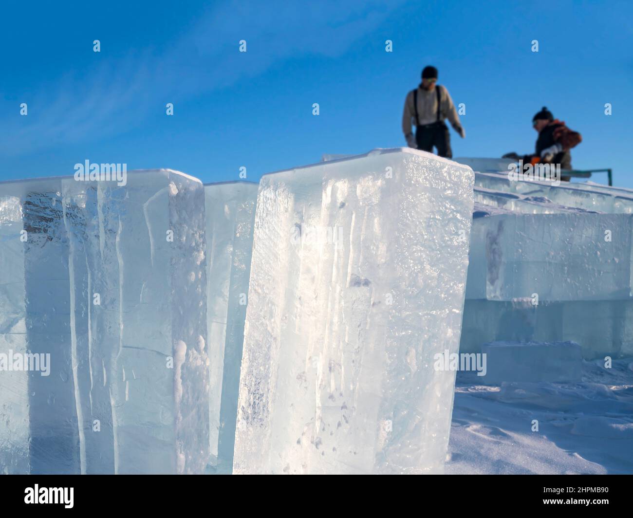 Making ice sculptures. Men level the surface in the ice with a gasoline ...