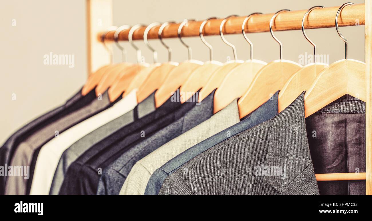 Mens suits in different colors hanging on hanger in a retail clothes ...