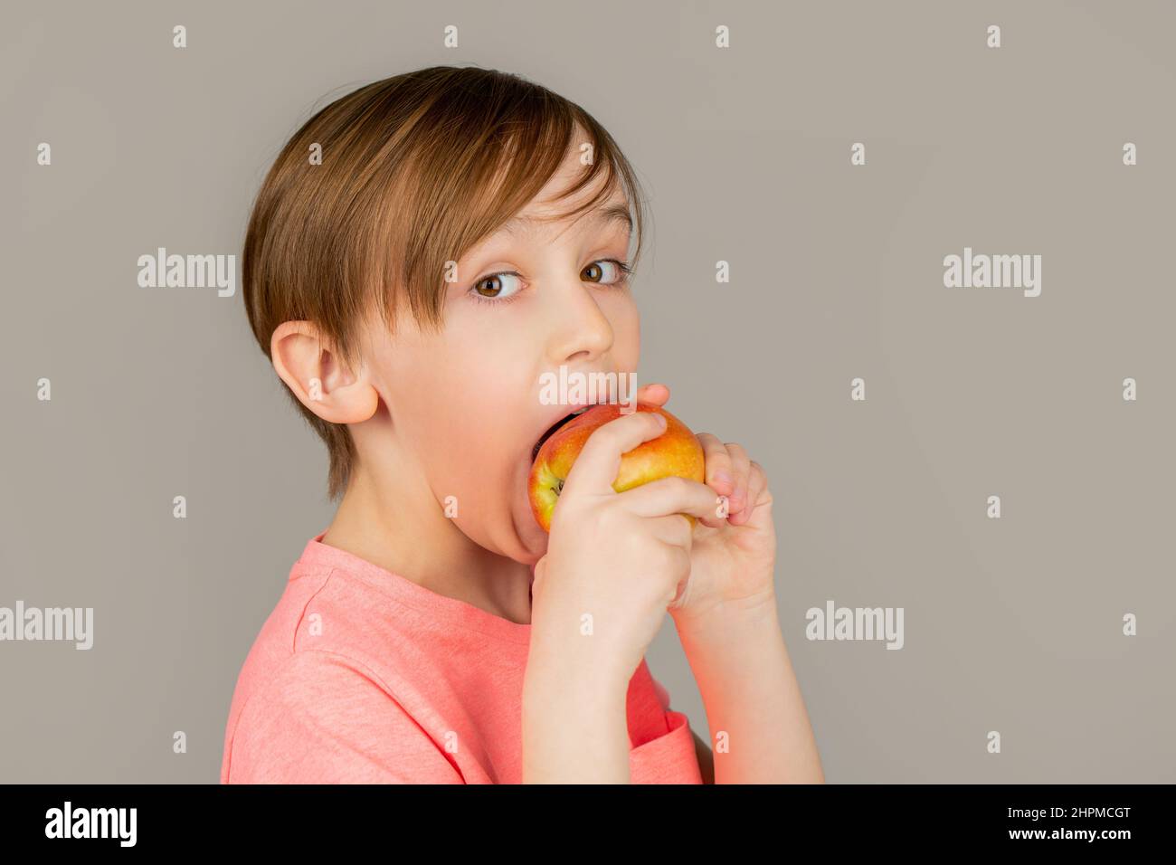 Portrait of cute little kid holding an apple. Baby boy eating apple and ...