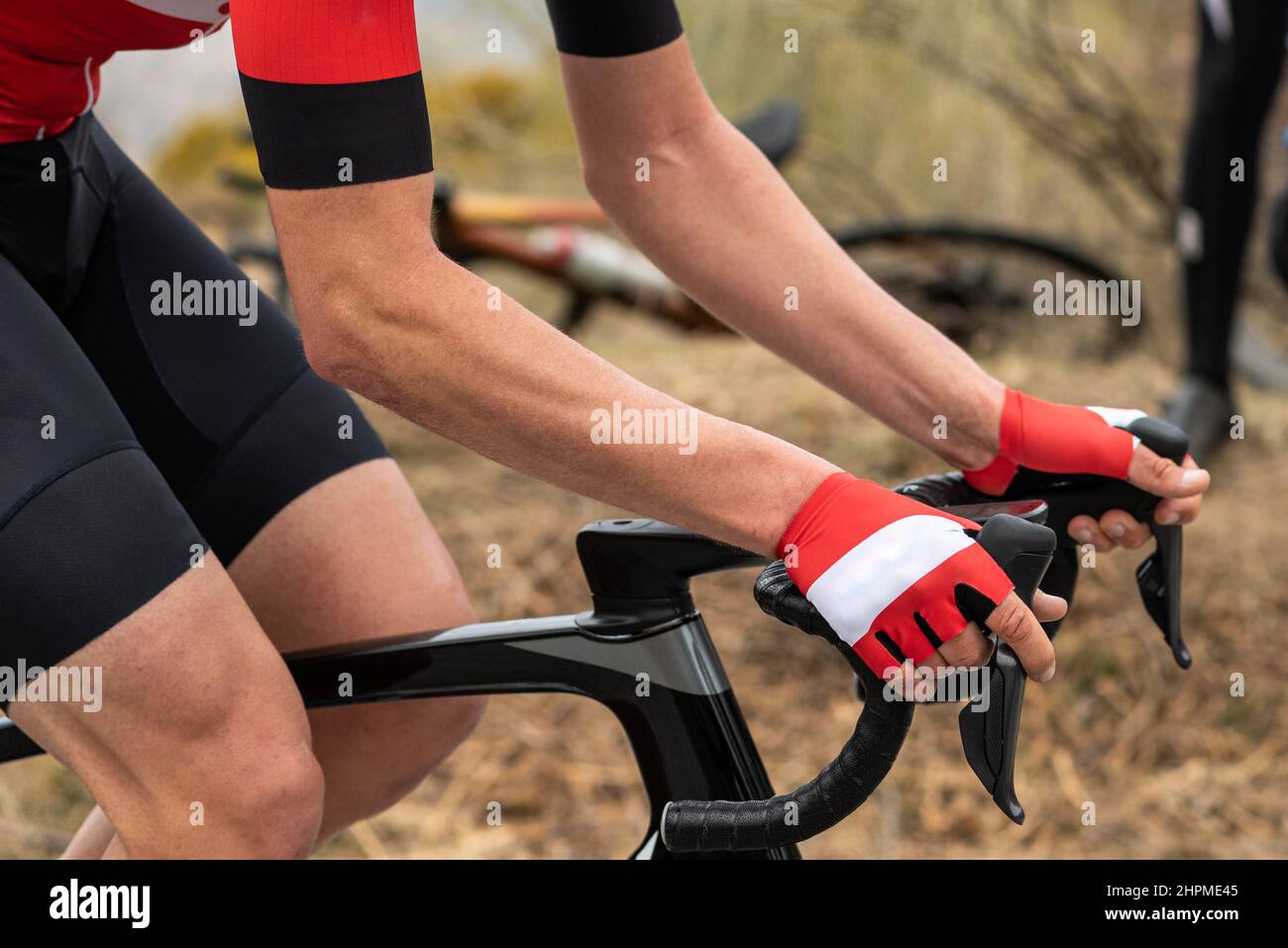 Cropped photo of the shoulders, arms and hands of an outdoor cyclist ...