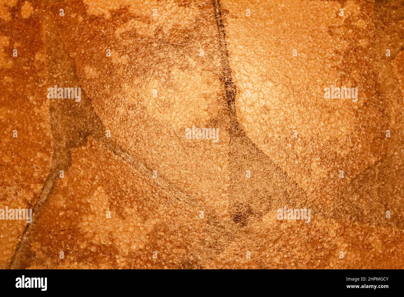 Photo of orange toned frozen concrete tile surface covered in ice ...