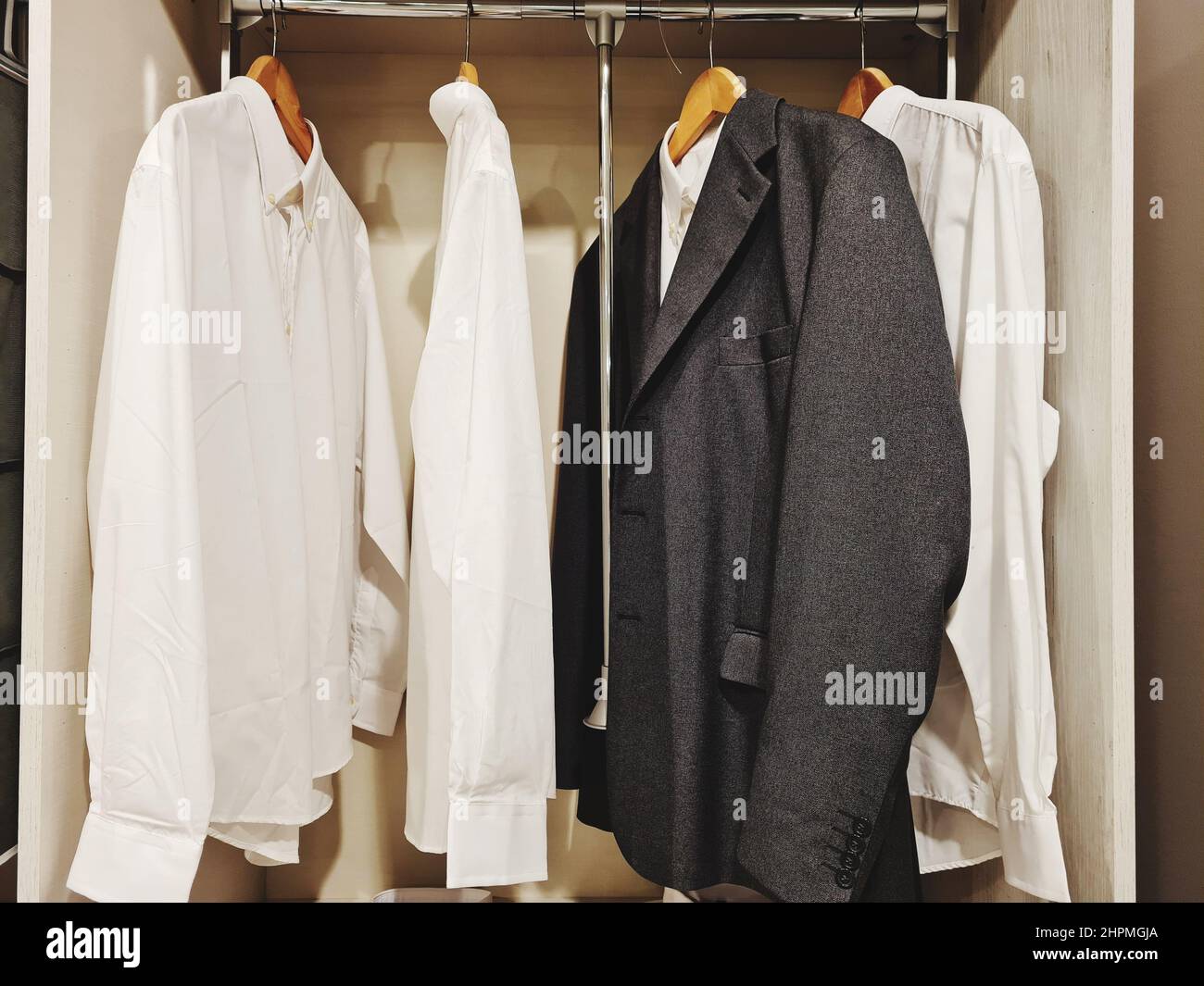 Suits and jackets hanging in an open walk-in closet Stock Photo - Alamy