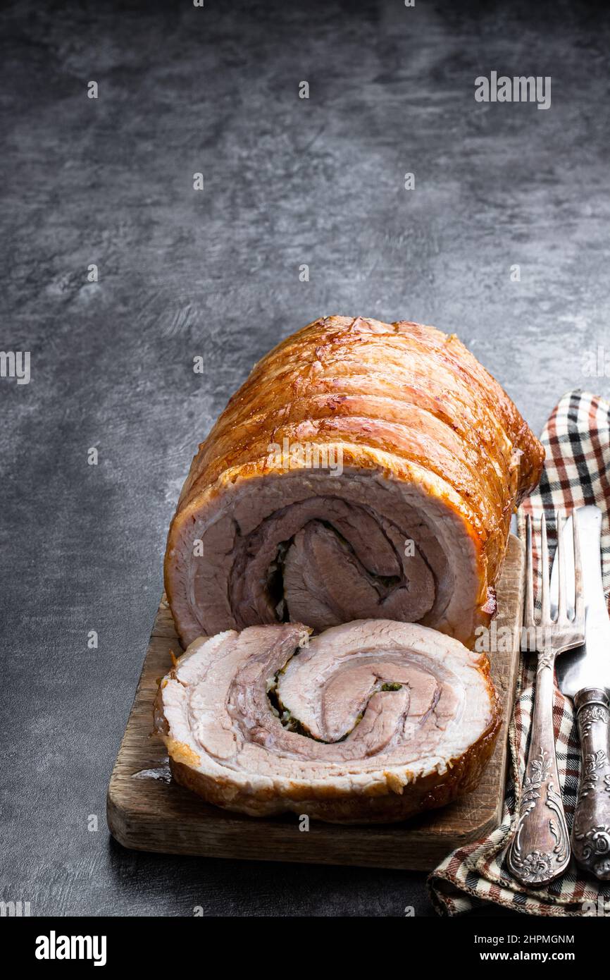 Roasted pork meat roll with herbs and spices on gray stone background ...