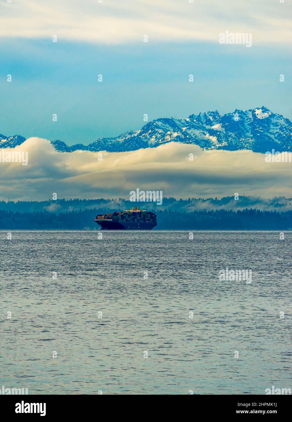 A ship crossed the Puget Sound with the Olumpic Mountain Range behind ...