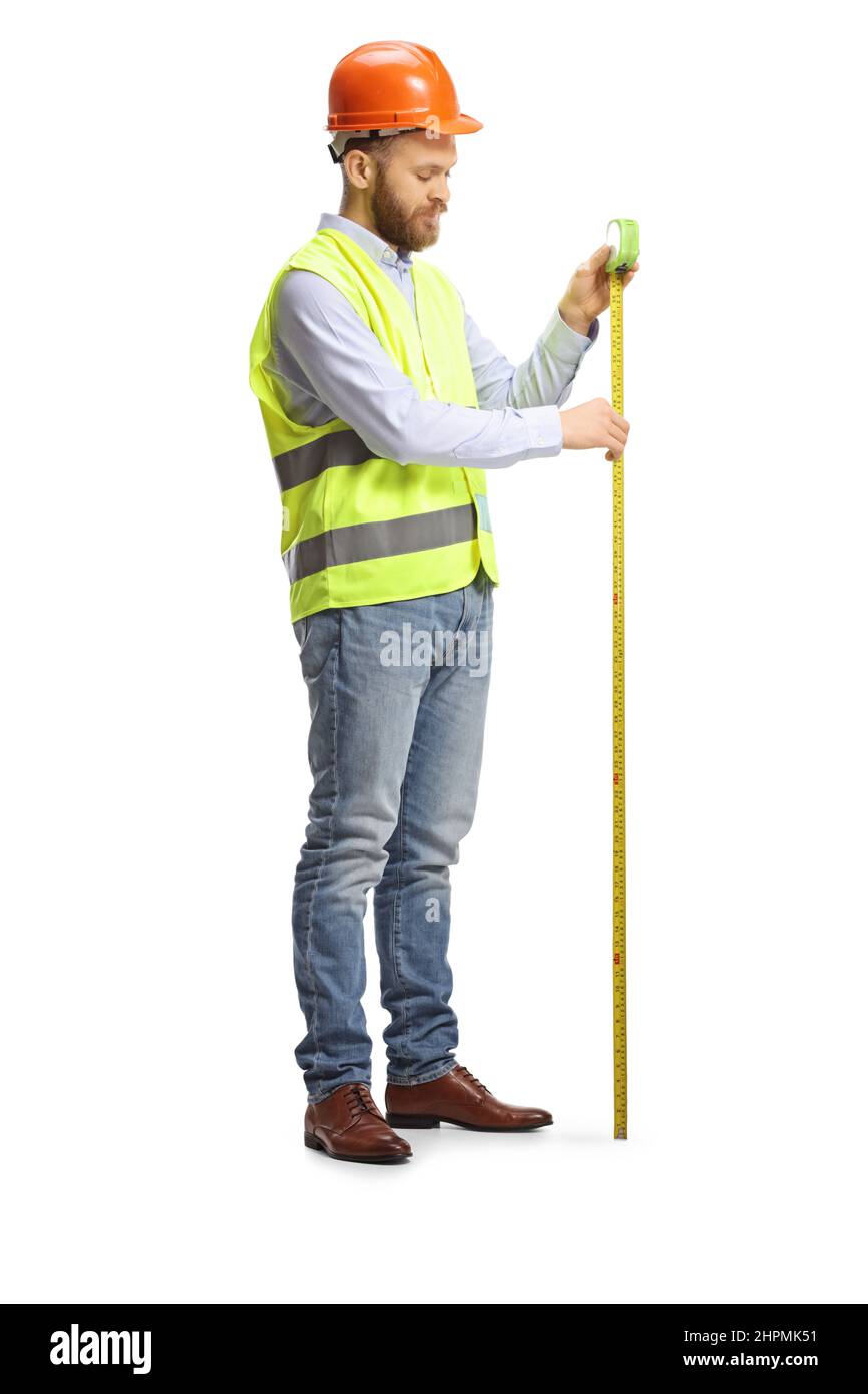 Full length shot of a male engineer measuring using a steel tape ...